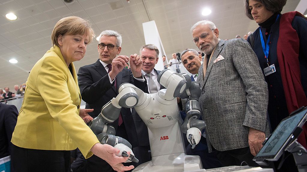 The Chancellor shakes hands with robot YuMi. Designed to assemble small ...
