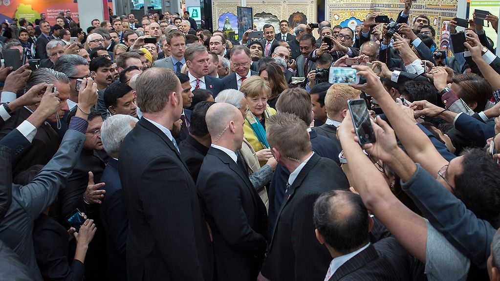 Angela Merkel and Narenda Modi are surrounded by journalists during the ...